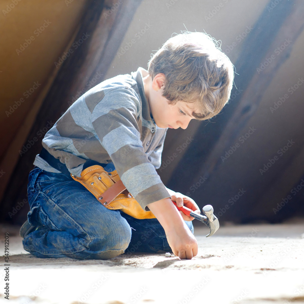 Little kid boy helping with toy tools on construction site. Funny child ...
