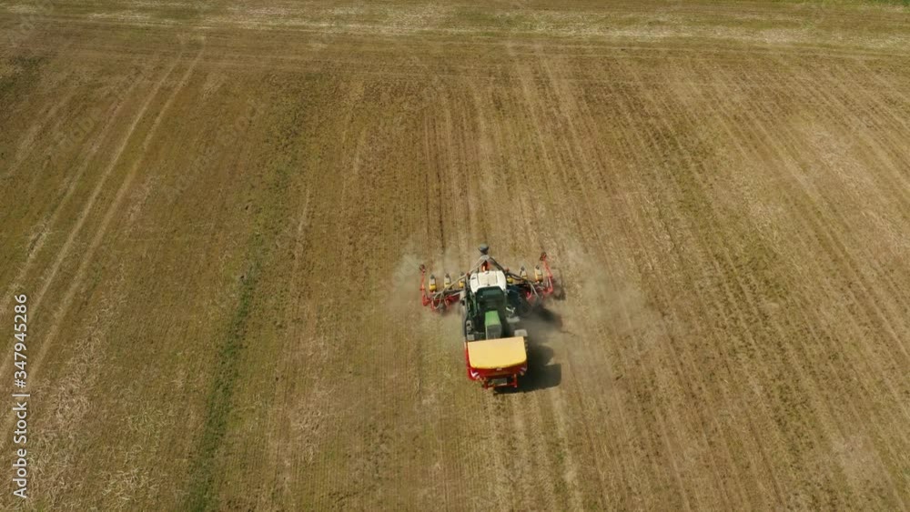 Tractor working in a field. Tractor with a seeder, sow crops at field ...