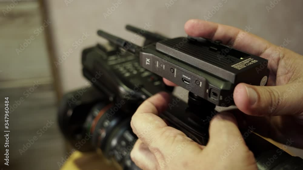 Installing the transmitter on the video camera. Stock Video | Adobe Stock