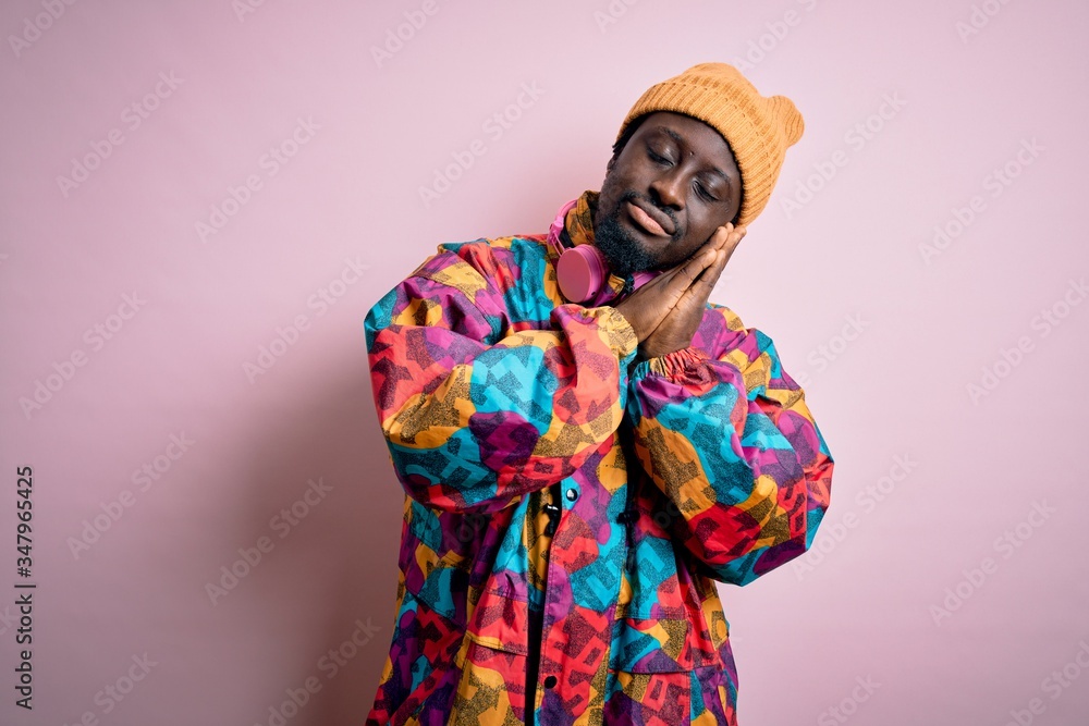 Young handsome african american man wearing colorful coat and cap over ...
