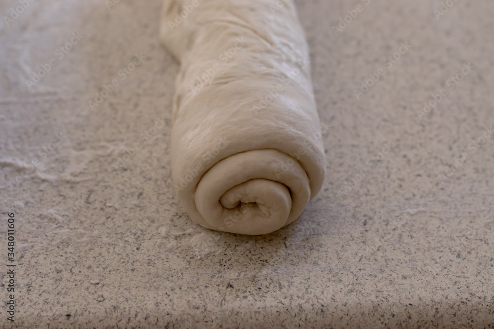 Rolled bread dough on a floured kitchen counter waiting to be shaped ...