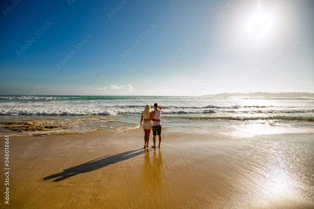 Romantic couple in love hugging, kissing and running on the sandy ...