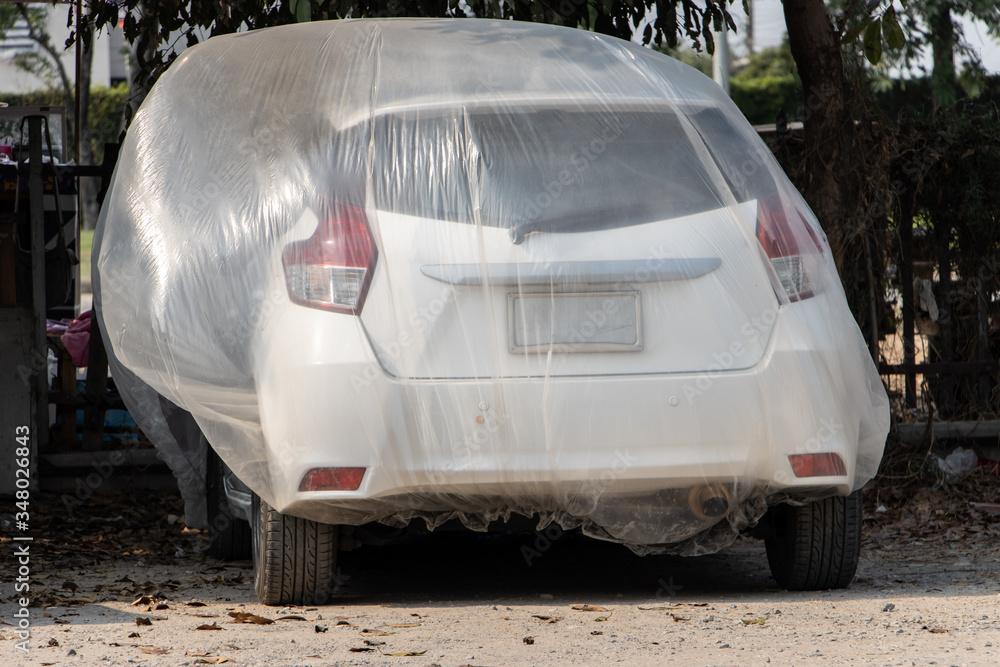 Car covered with large plastic bag for prevention. Protection of ...