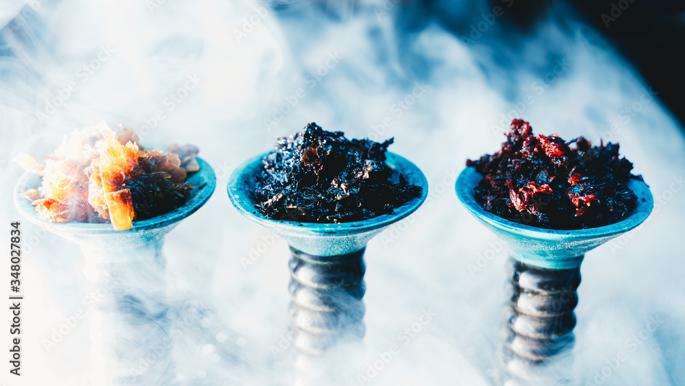 Side view of different kinds of hookah tobacco on smoky bar counter ...