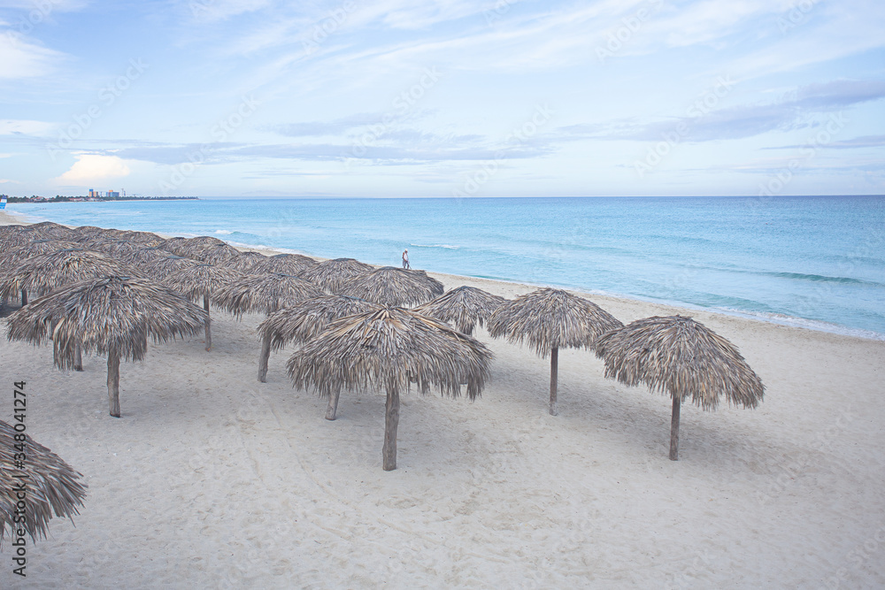 Row of thatched umbrellas at the famous Varadero beach in Cuba on a ...