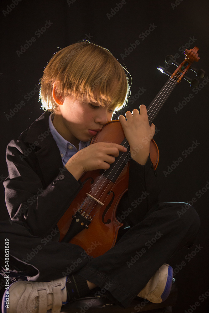 boy hugging his violin, in an attitude of love for music Boy shows his ...
