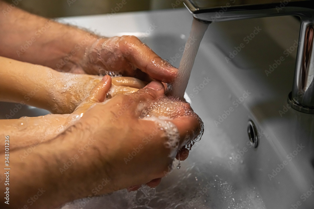 washing hands with soap. Washing a child’s hands with soap and water to ...