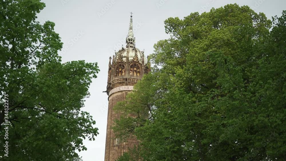 Tower of Castle Church in wittenberg germany seem through tree canopy ...