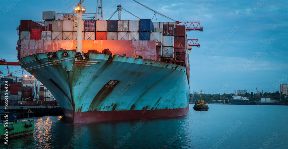 Container cargo ship load in the seaport at dusk. Logistics and ...