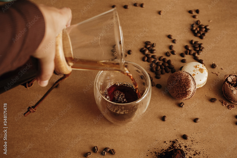 Making drip coffee. Hand pouring fresh coffee from glass flask in cup ...