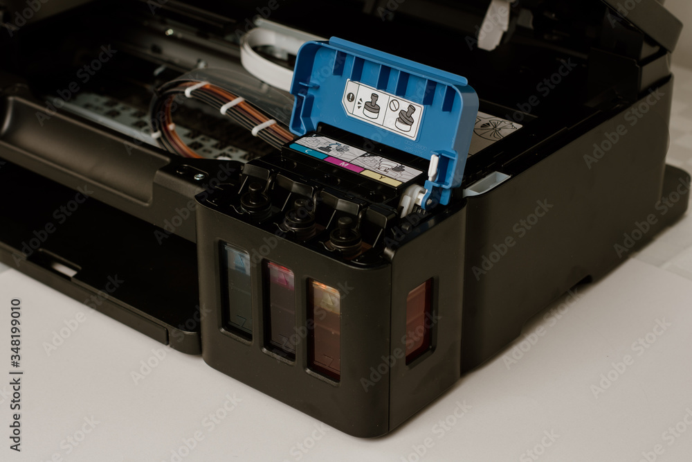 Up close, ink tanks from a printer displaying CMYK Cyan, Magenta ...