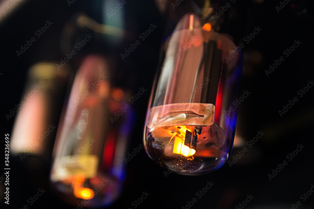 Electrical light buld with purple, yellow, orange light and wire inside ...