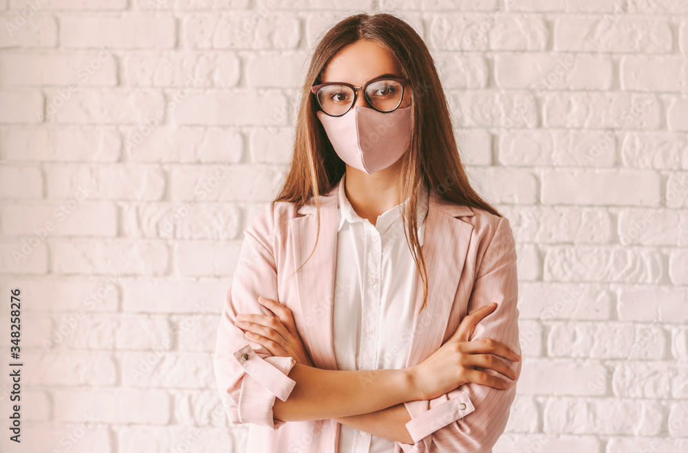 Portrait confident young female entrepreneur in protective face mask ...