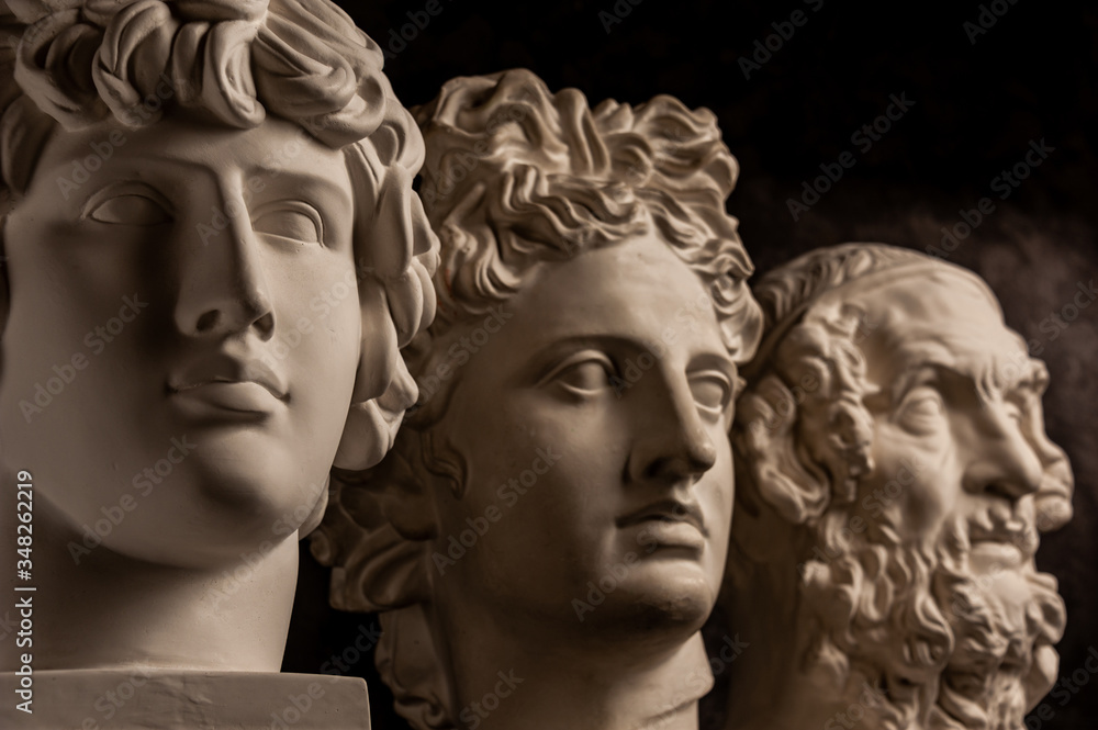 Group gypsum busts of ancient statues human heads for artists on a dark ...