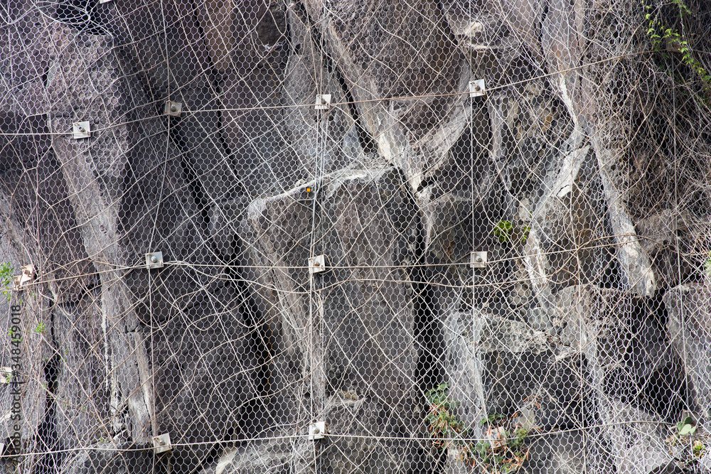 Slope of the mountain with a rockfall protection net preventing rocks ...