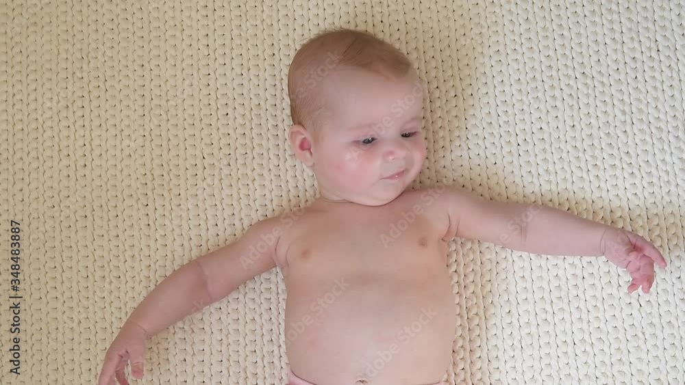 newborn baby without clothes lies on a white textured background, close ...
