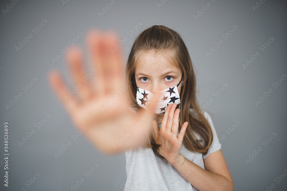 beautiful young girl with self-made mouth nose mask in front of grey ...