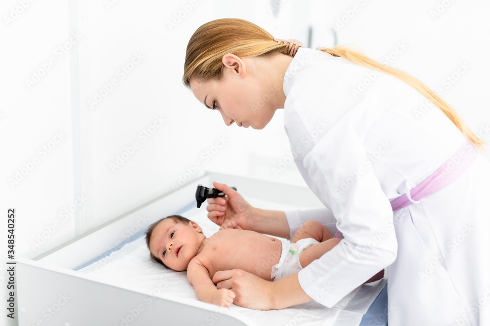 Pediatrician examines 2 week old baby's ear in new pediatric clinic ...