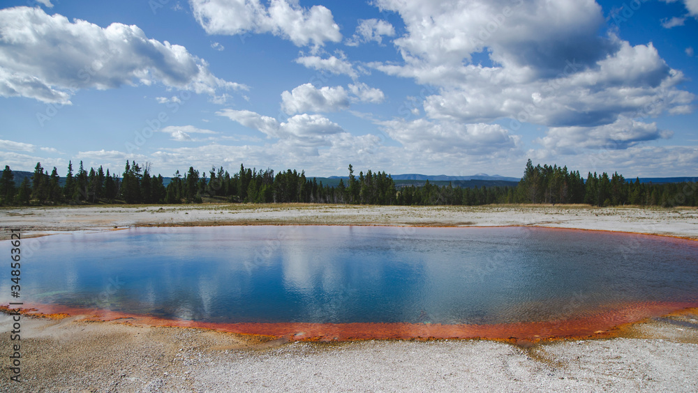 Dark blue orange basin on forest and mountains background with small ...