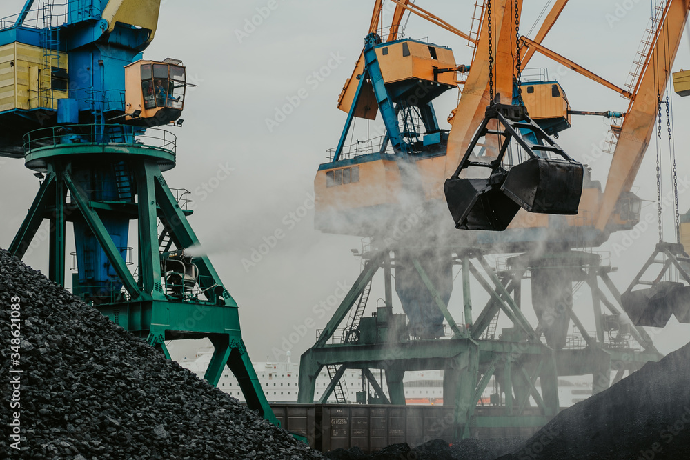port cranes are loading coal into a transporting train.port cranes are ...