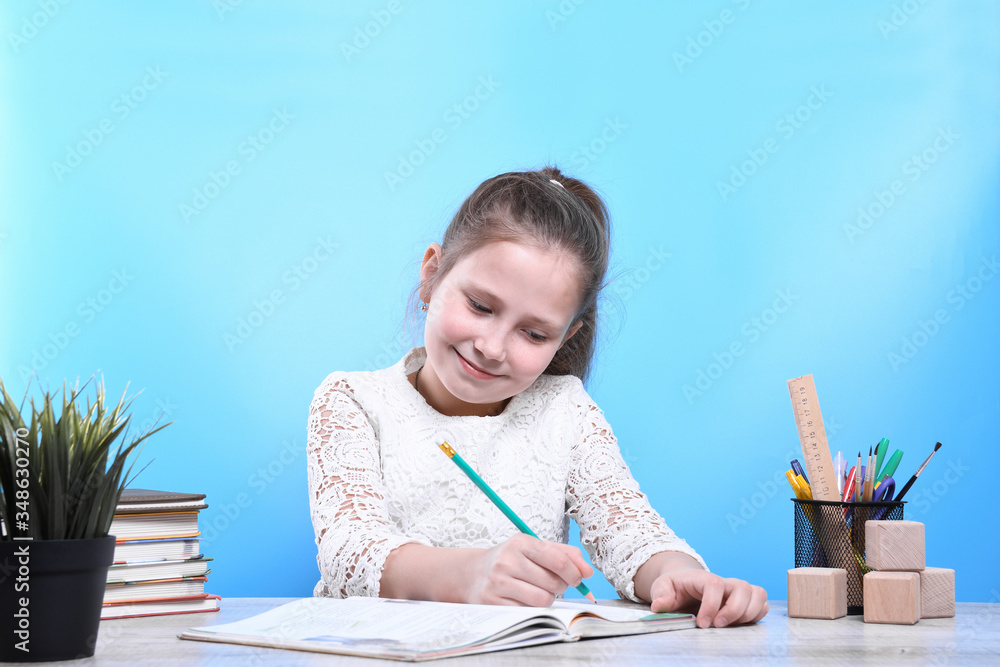 Back to school .Happy cute industrious child is sitting at a desk ...