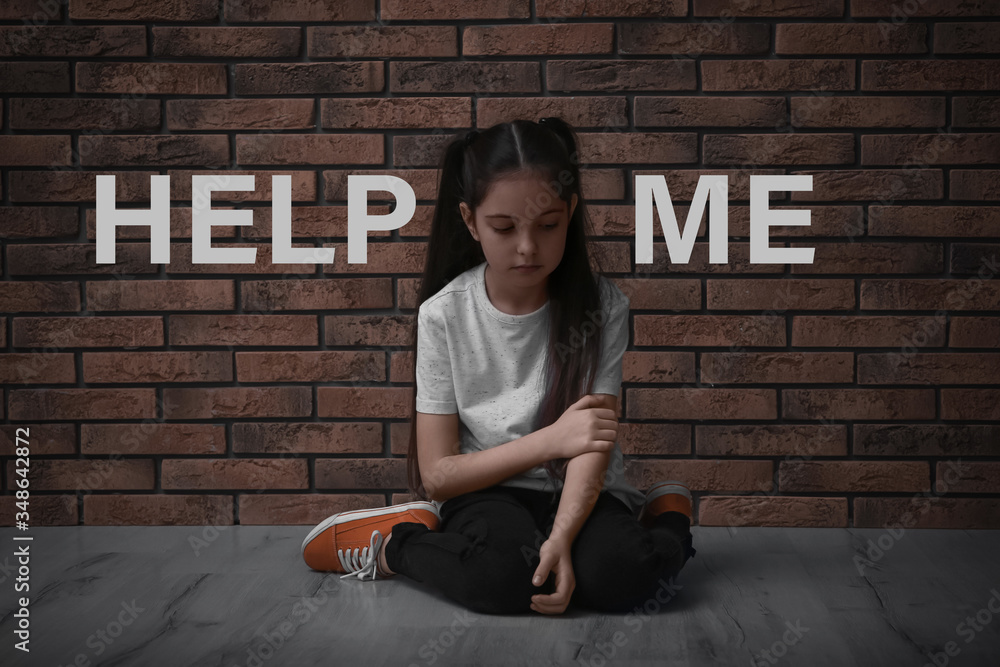 Sad little girl near brick wall and text HELP ME Stock Photo | Adobe Stock