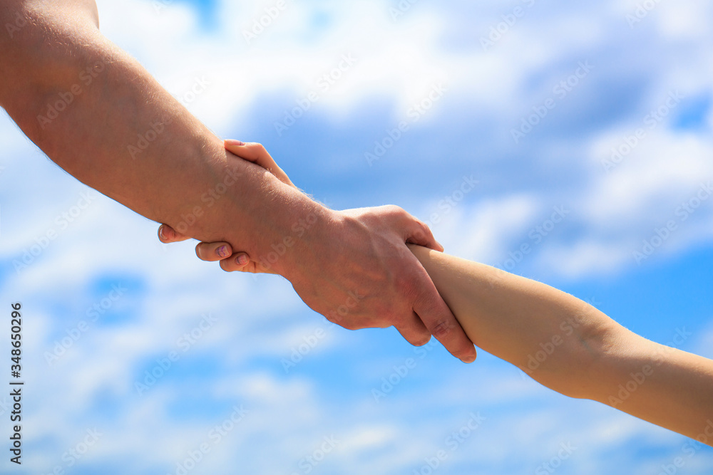 Giving a helping hand. Hands of man and woman on blue sky background ...
