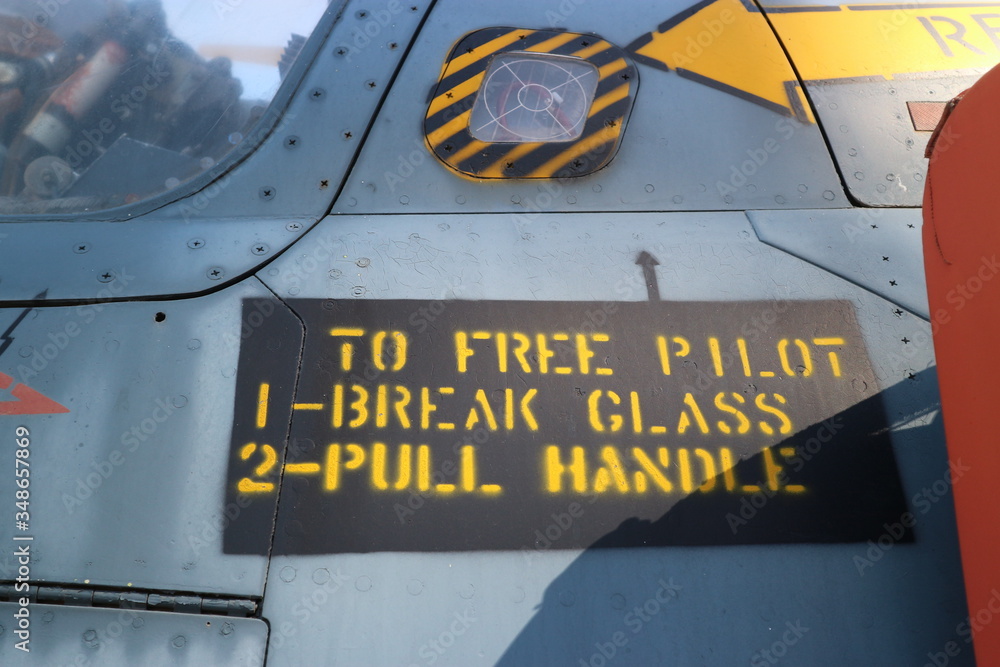 Detail of a military airplane. Sign with instructions how to open the ...