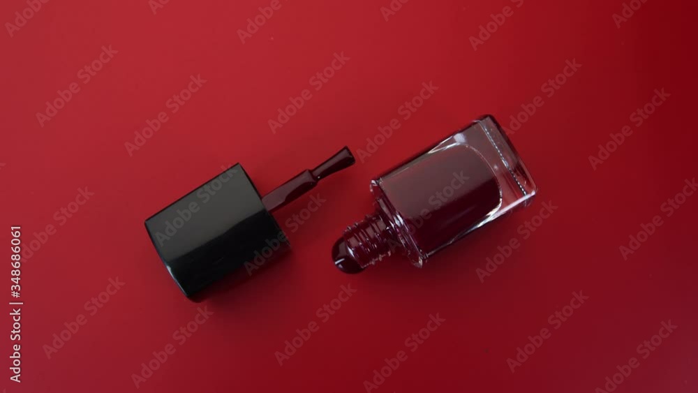 Bottle of nail polish lies on red background. Red nail polish drips ...