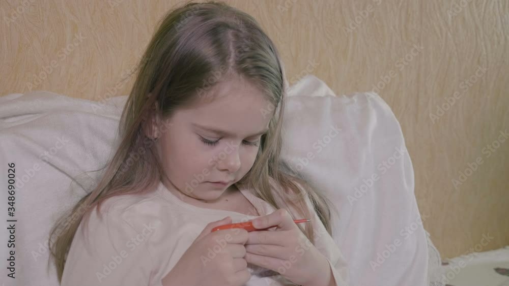 Symptoms of fever and coronavirus, a girl measures body temperature ...