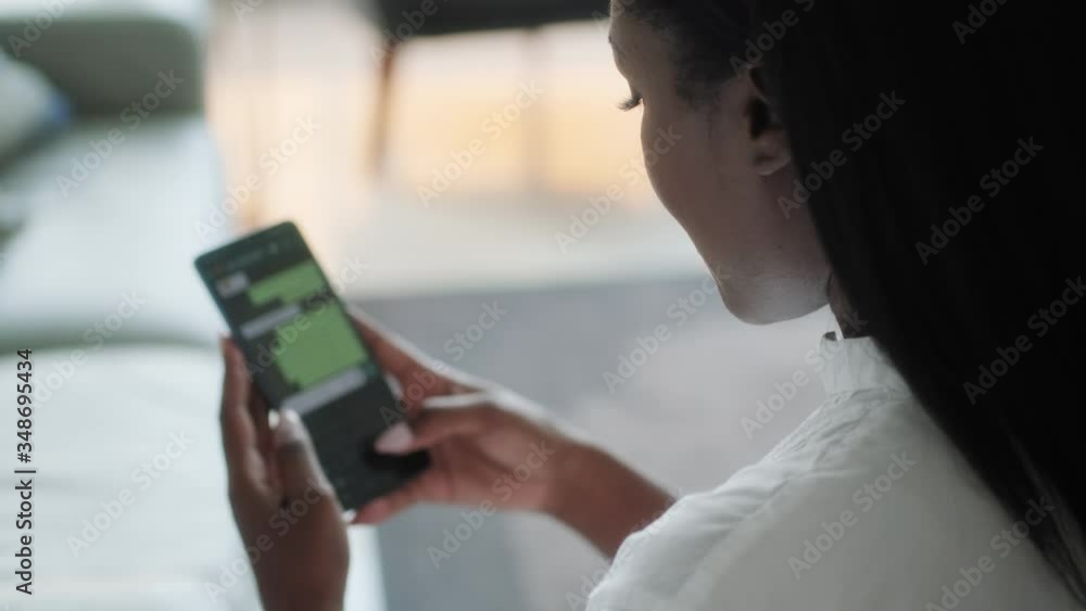 African American woman sending text message and photo with Whatsapp on ...