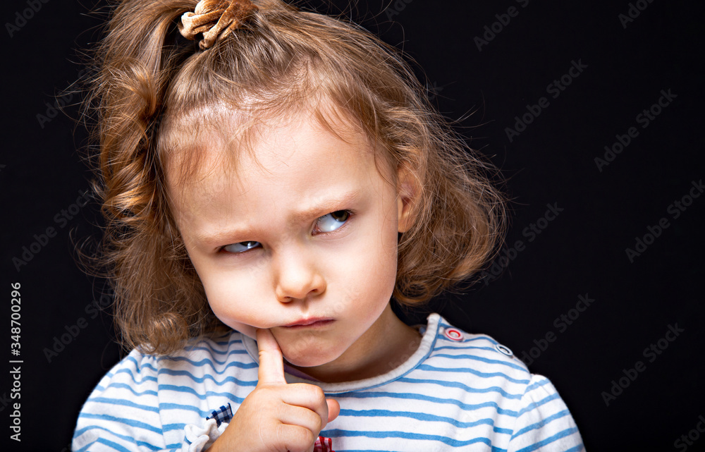Cute small kid girl with serious angry face looking up and decided the ...