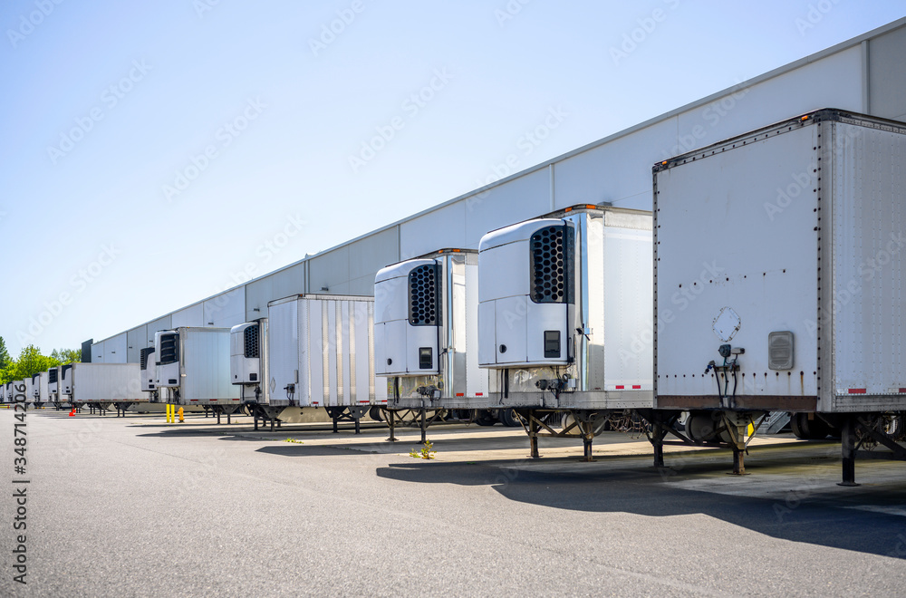 Different semi trailers without semi trucks standing at long warehouse ...