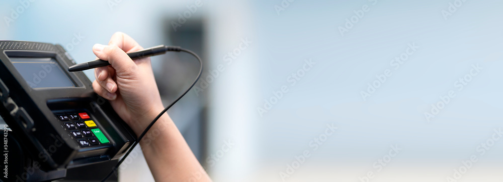 closeup female hand sign and pay money by credit card cashier counter ...