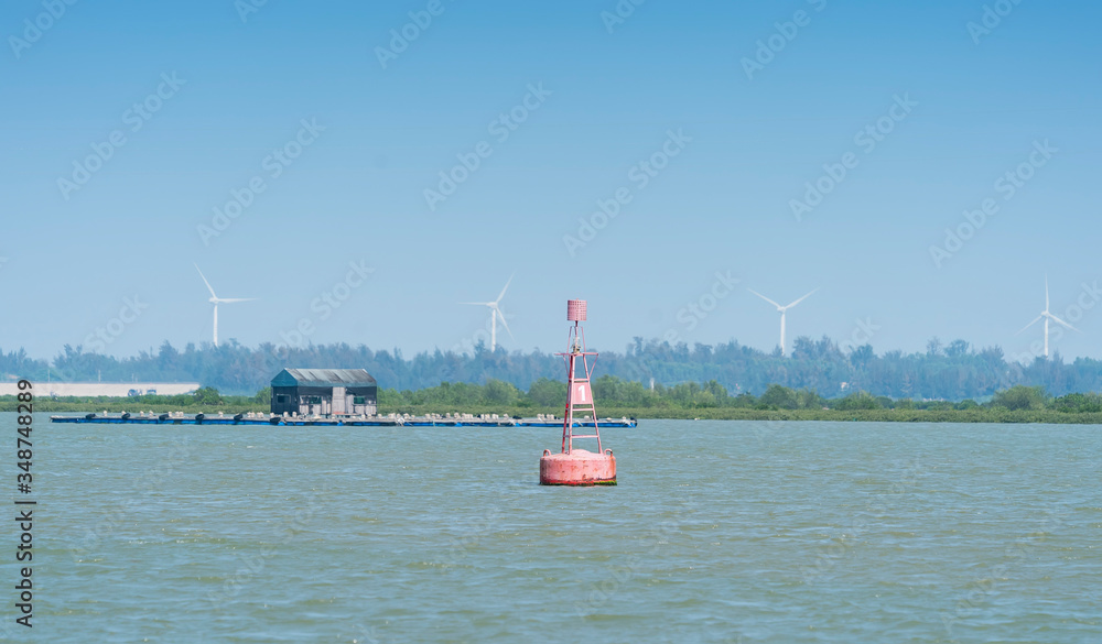The floating sign of a red buoy nchored to indicate navigational ...