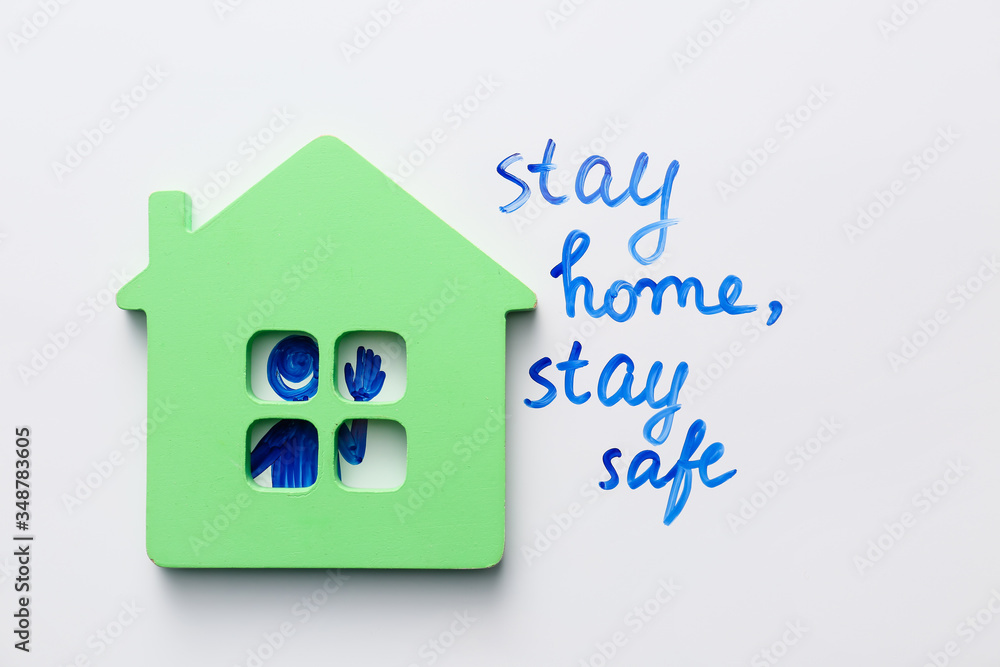 Model of house with drawn human figure and text STAY HOME, STAY SAFE on ...