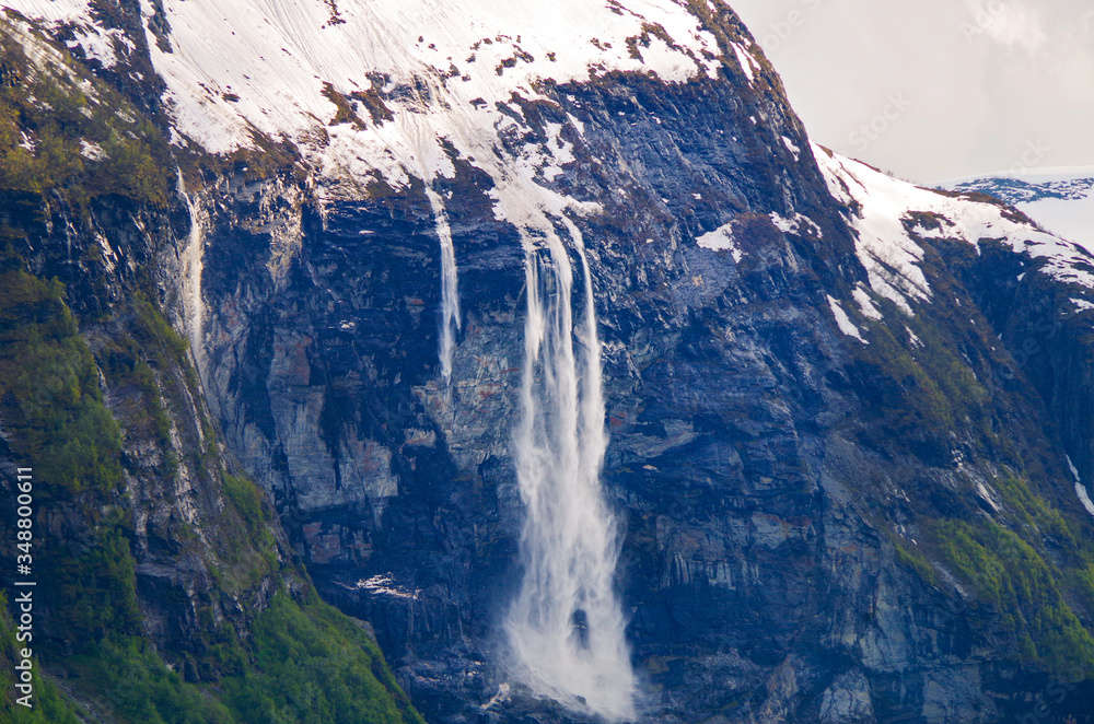 Avalanche of snow cascading down steep mountain or cliff in ...