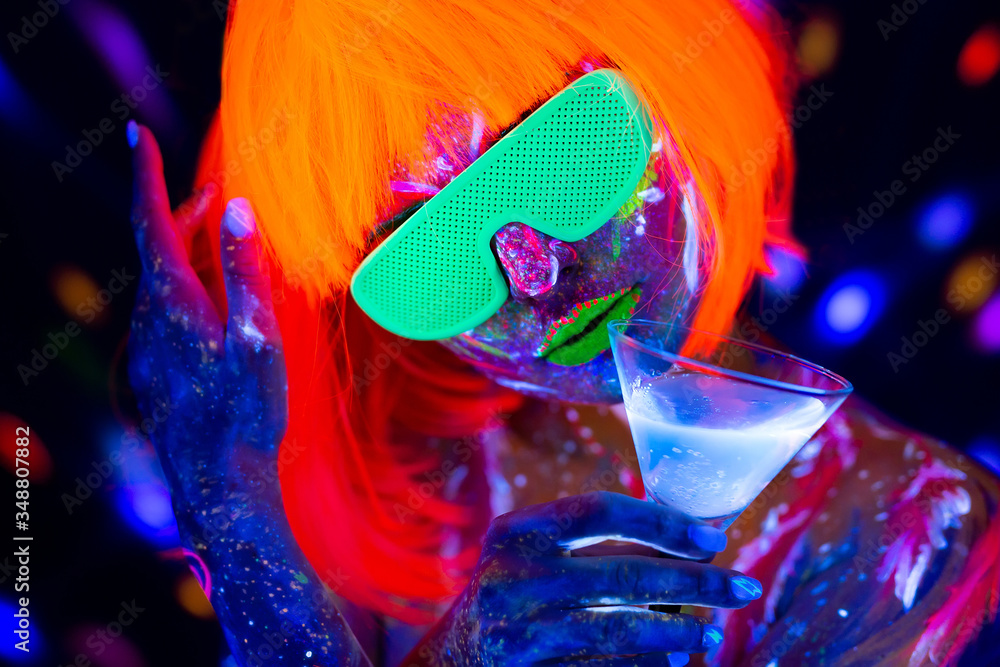 Fashion model woman drinking alcoholic cocktail in neon light, disco ...
