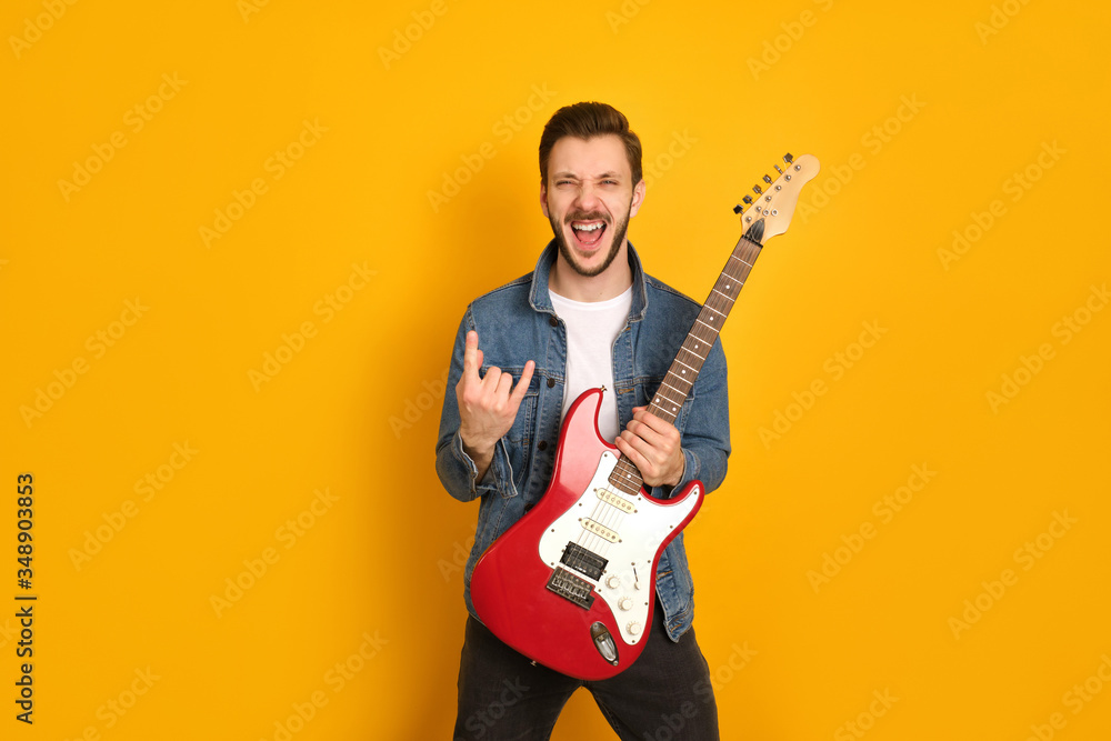 A portrait of crazy handsome musician holding electric guitar with one ...