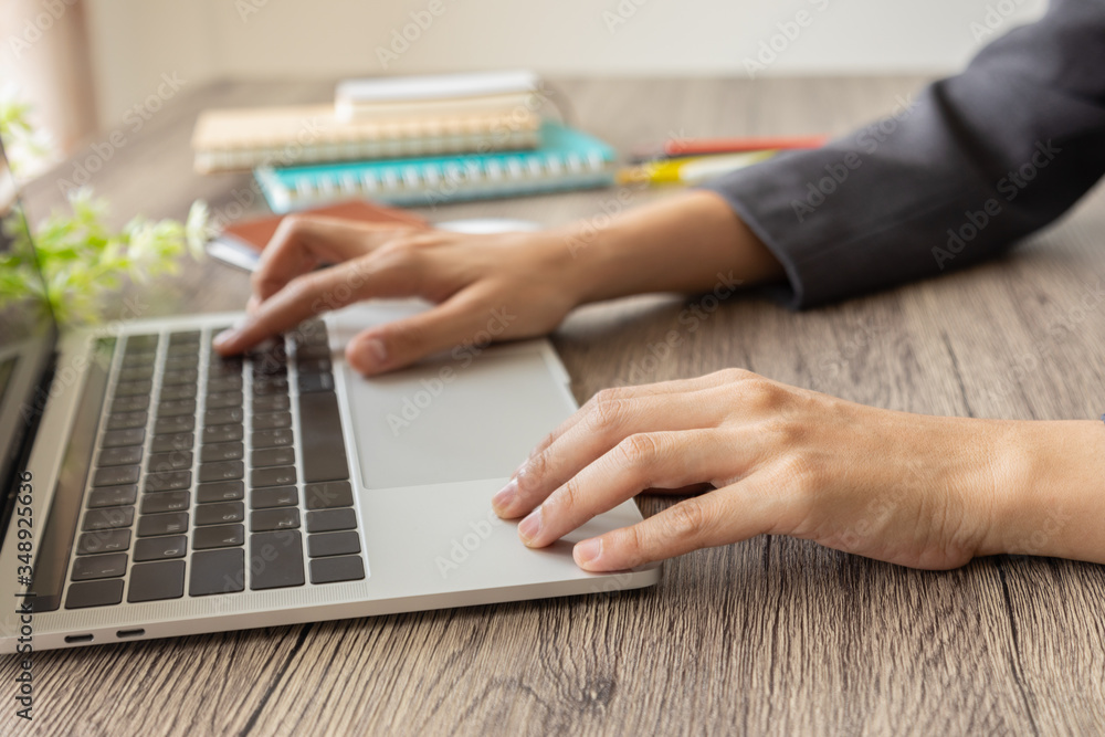 A side view with selective focus of a business desk with hand typing on ...
