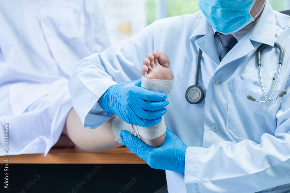 Close-up hand wear medical gloves doctor examines the leg of the woman ...
