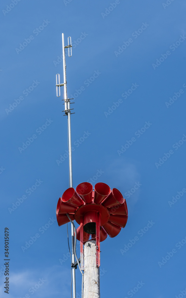 Red Fire house sirens on a wood pole with dipole antennas attached ...