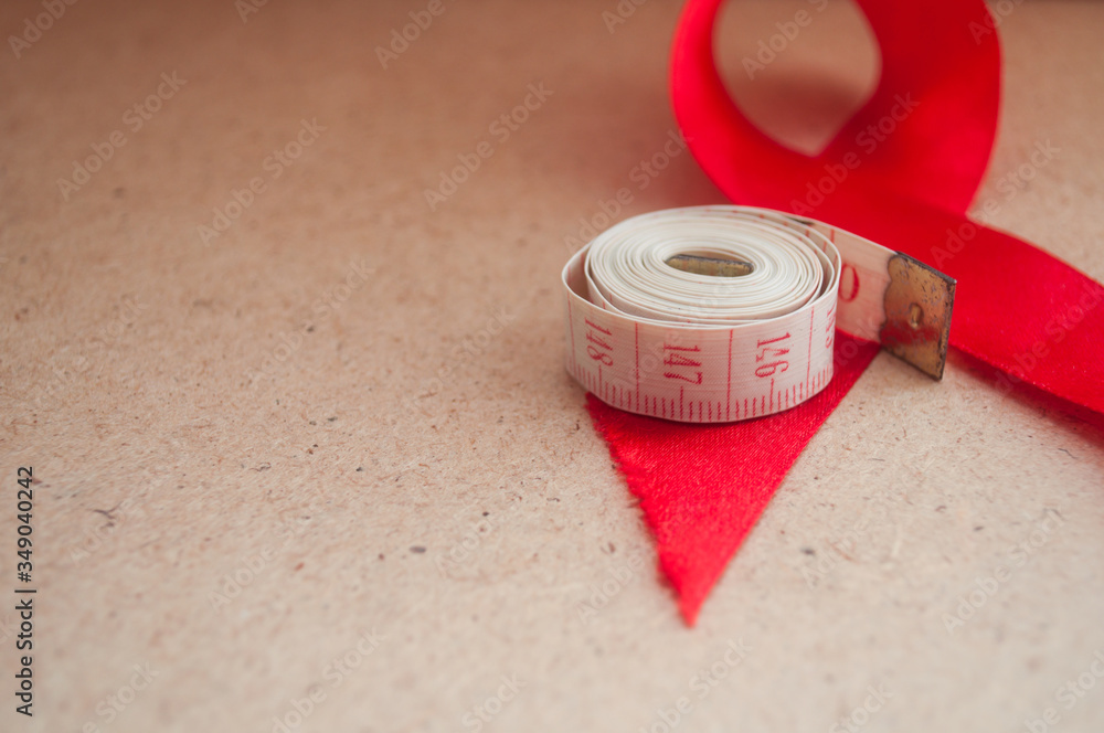 Red awareness ribbon and measuring tape. The problem of aneroxia ...