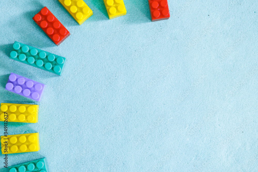 multi-colored parts of the constructor. rectangular toys on a blue ...