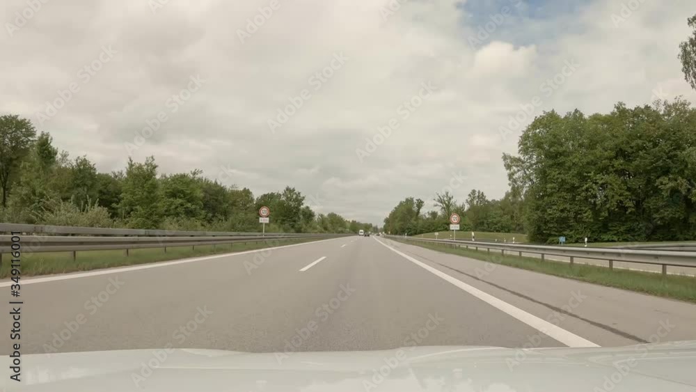 Driving fast at a german highway (Autobahn), passing by green field at ...