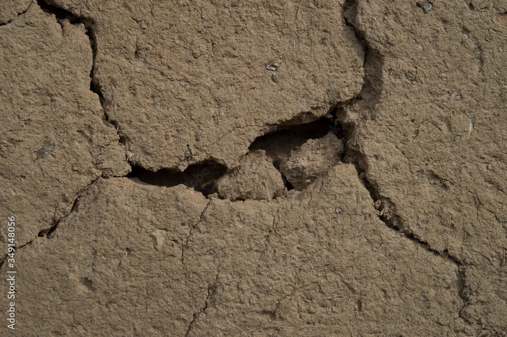 Huge wide cracks and a hole in the old clay wall of the house ...