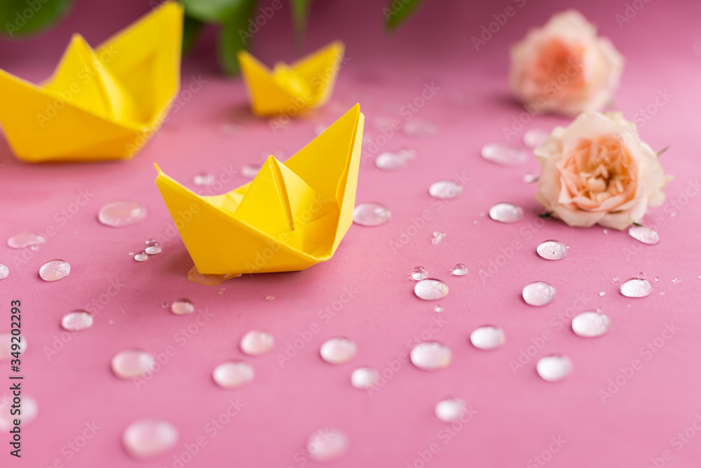 Yellow spring paper ships,boats floating in sparkling water drops on ...