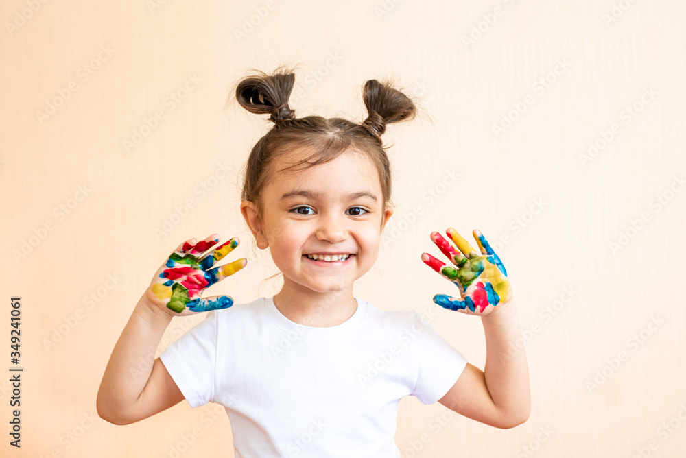 Happy little girl with painted hands. the child joyfully shows his ...