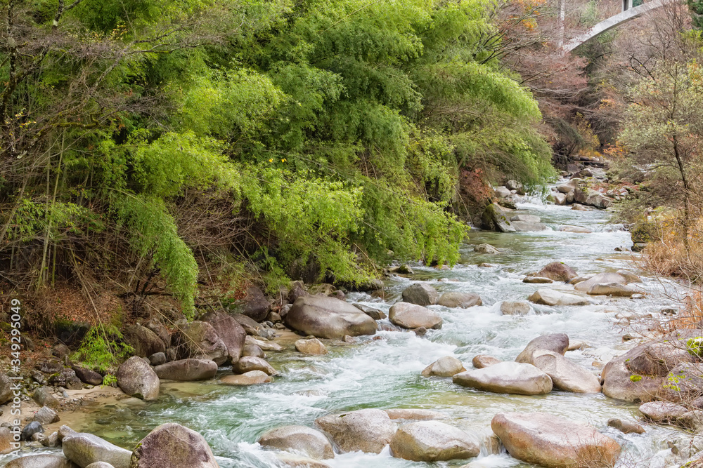 Waterfall and stones covered in moss, green area with unspoiled nature ...