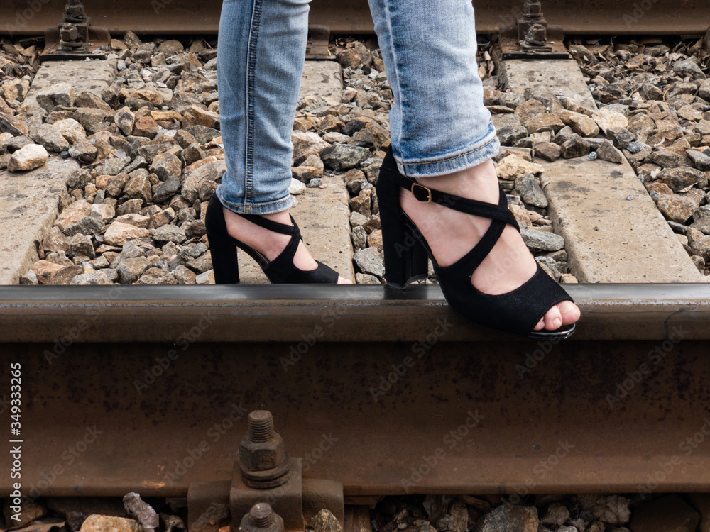 A girl walking on the rails on the high heels. Sexy legs in high heels ...
